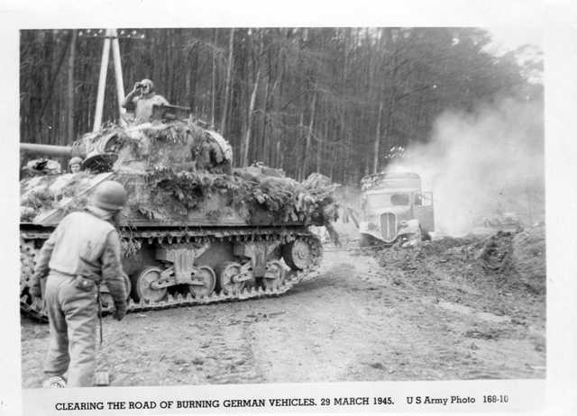 Clearing the road of burning German vehicles. 29-March-1945